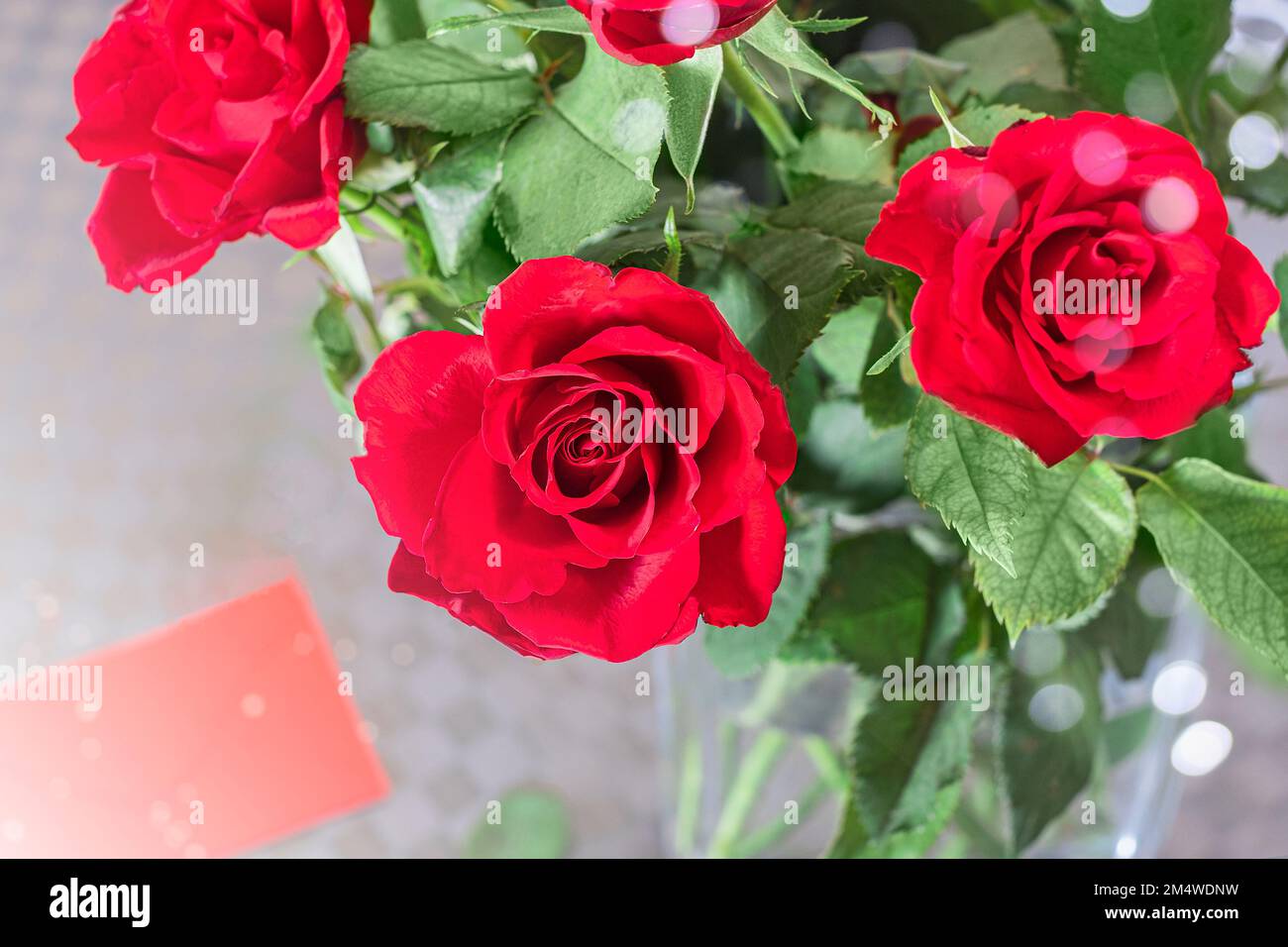 Red roses in glass vase on table. Top view Stock Photo - Alamy