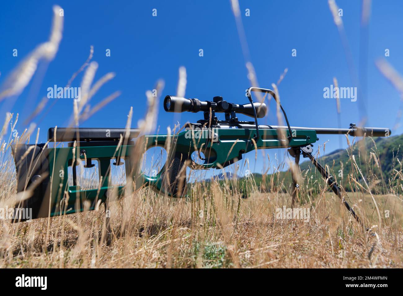 A green military sniper rifle with a scope for long distance tactical ...