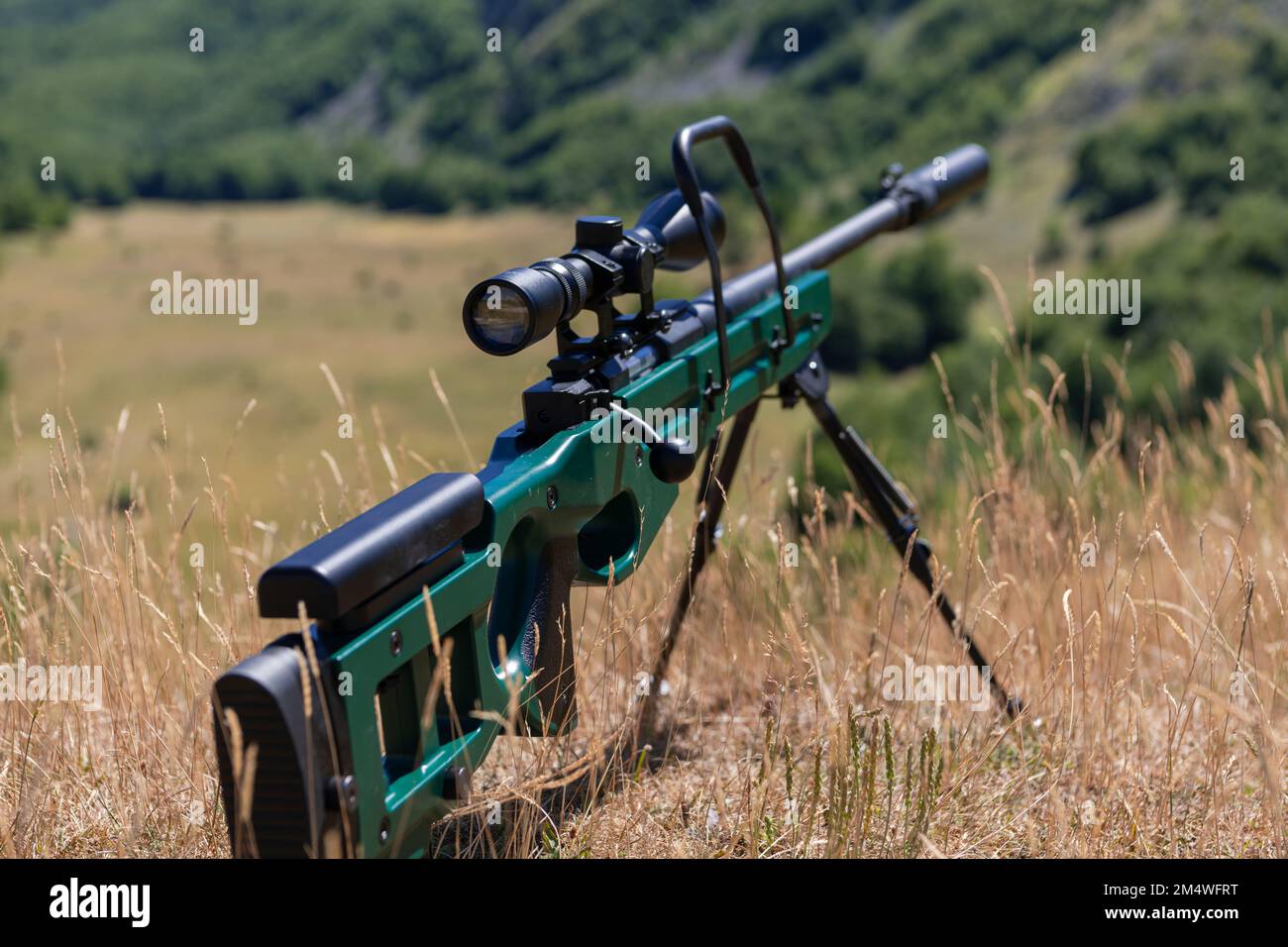 A green military sniper rifle with a scope for long distance tactical ...