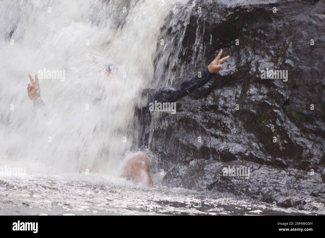Person on rock under waterfall hi-res stock photography and images - Alamy