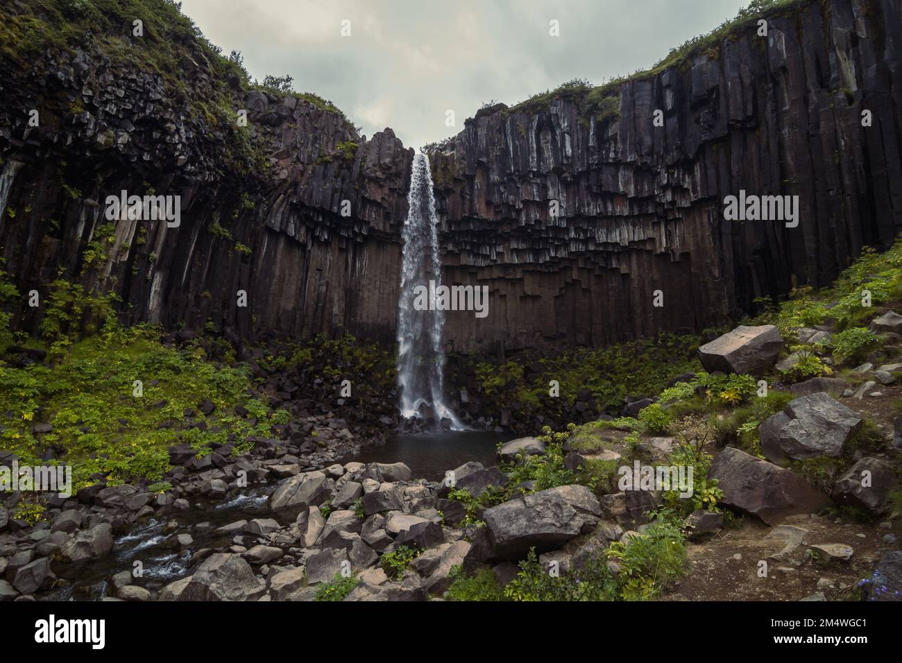 Narrow waterfall on high cliff landscape photo Stock Photo - Alamy
