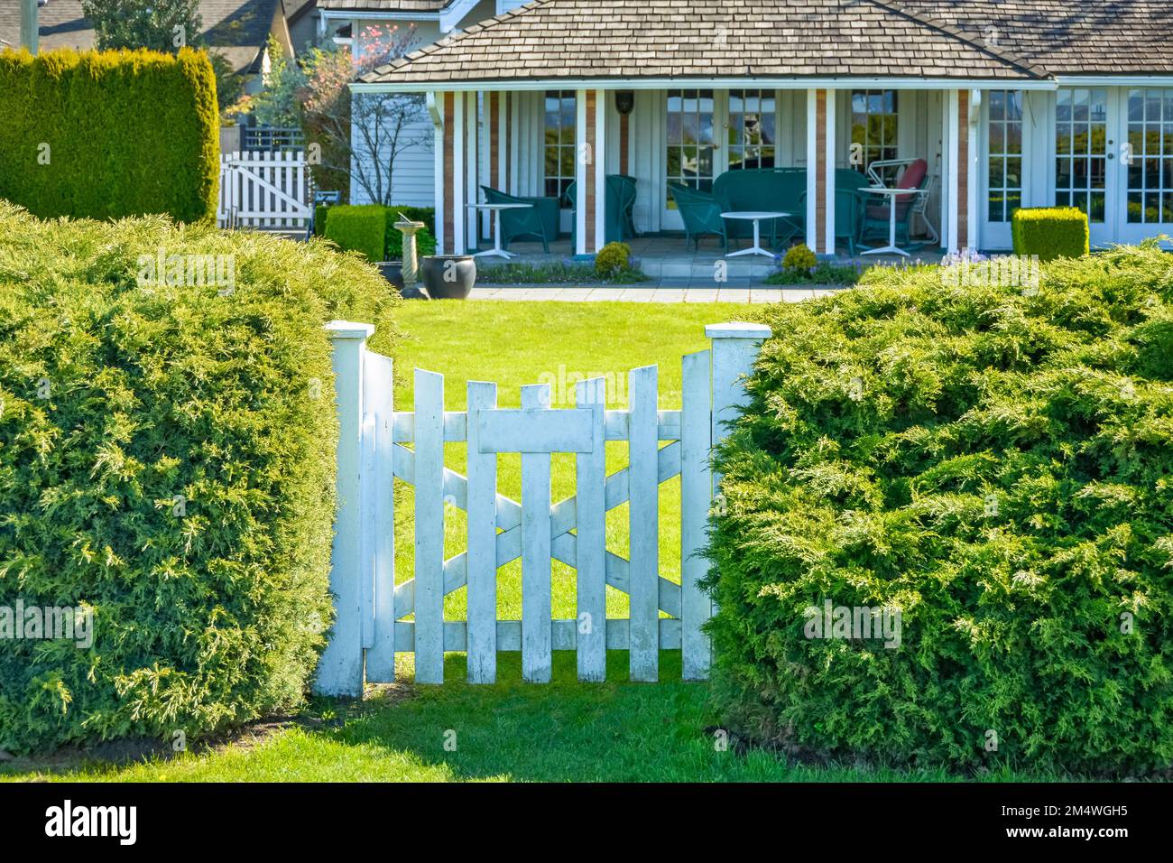 White wooden entrance gate leading to a front yard patio Stock Photo ...