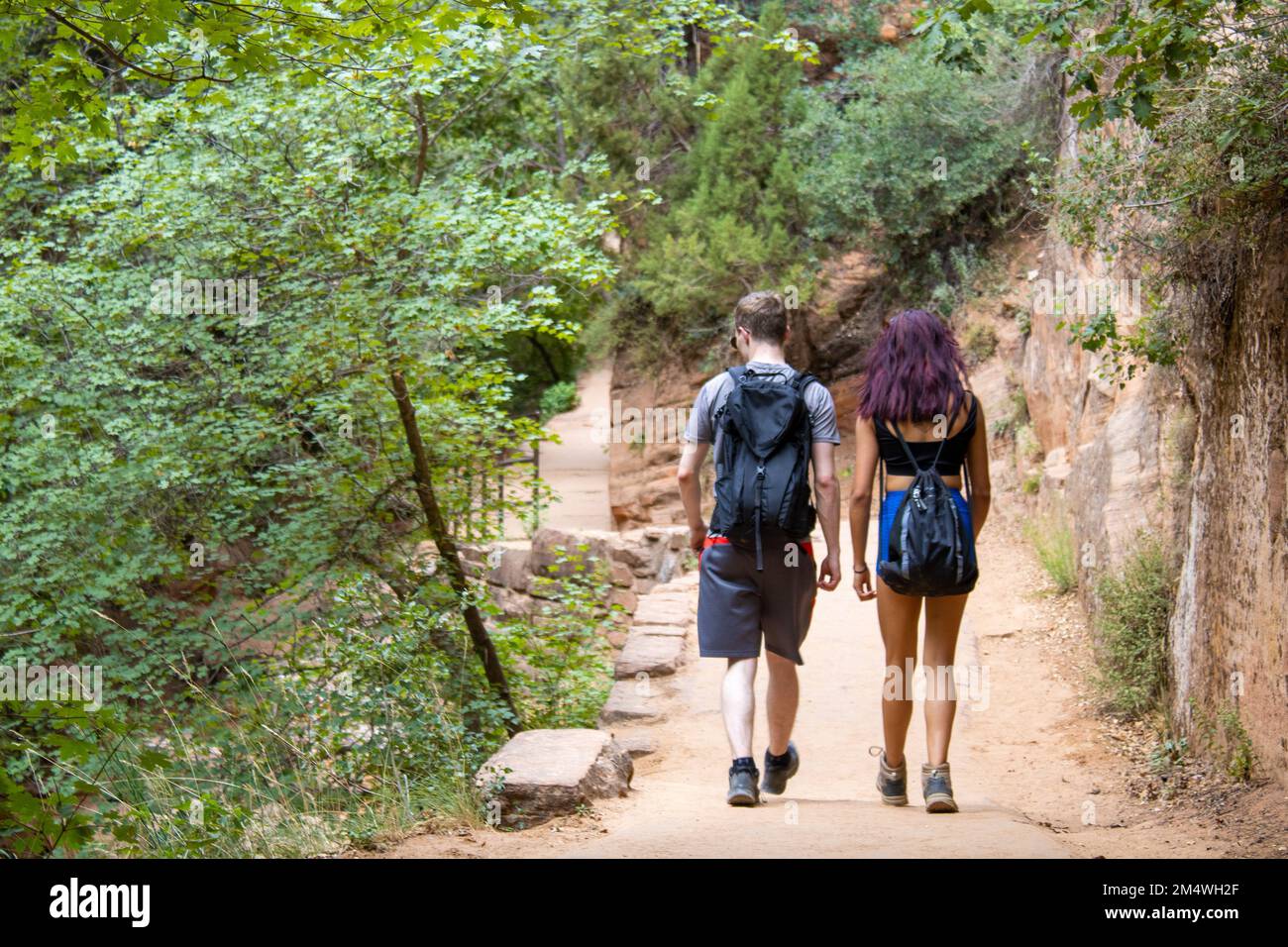 A young couple walking side by side down a hiking trail Stock Photo - Alamy