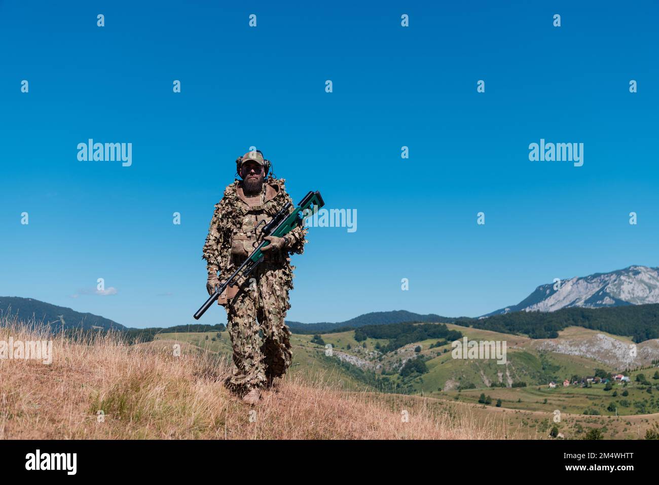 Army soldier holding a sniper rifle with scope and walking in the ...