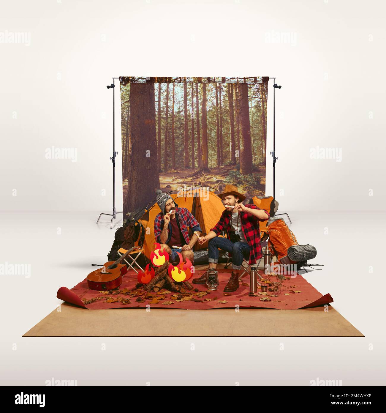 Two mates, men recreating camping activity over grey background with ...