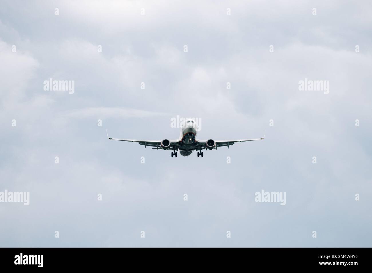 Passenger plane comes in for landing in cloudy weather Stock Photo - Alamy