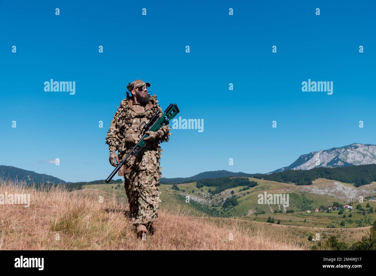 Army soldier holding a sniper rifle with scope and walking in the ...