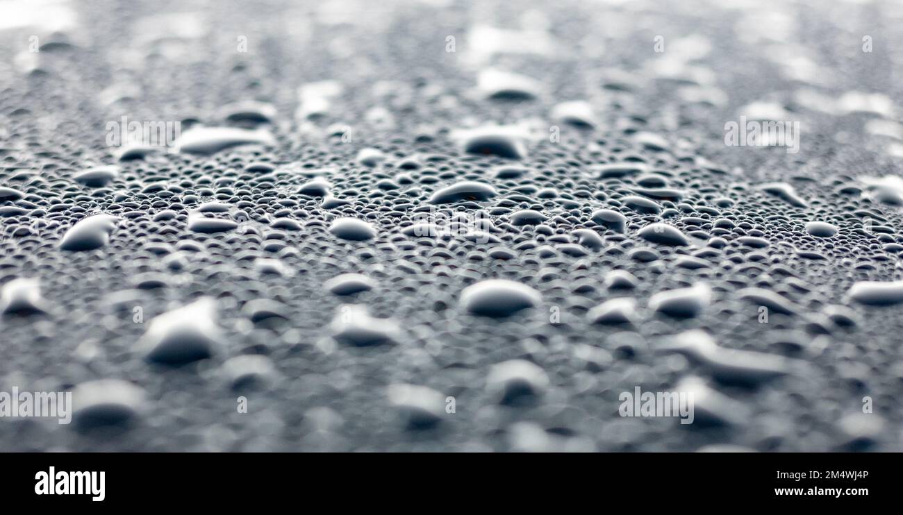 Dew drops on the black hood of a parked car. Background Stock Photo - Alamy