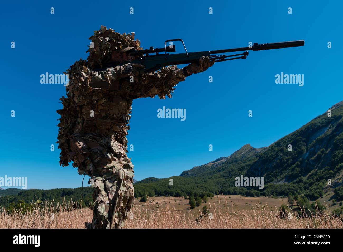 Army soldier holding a sniper rifle with scope and walking in the ...