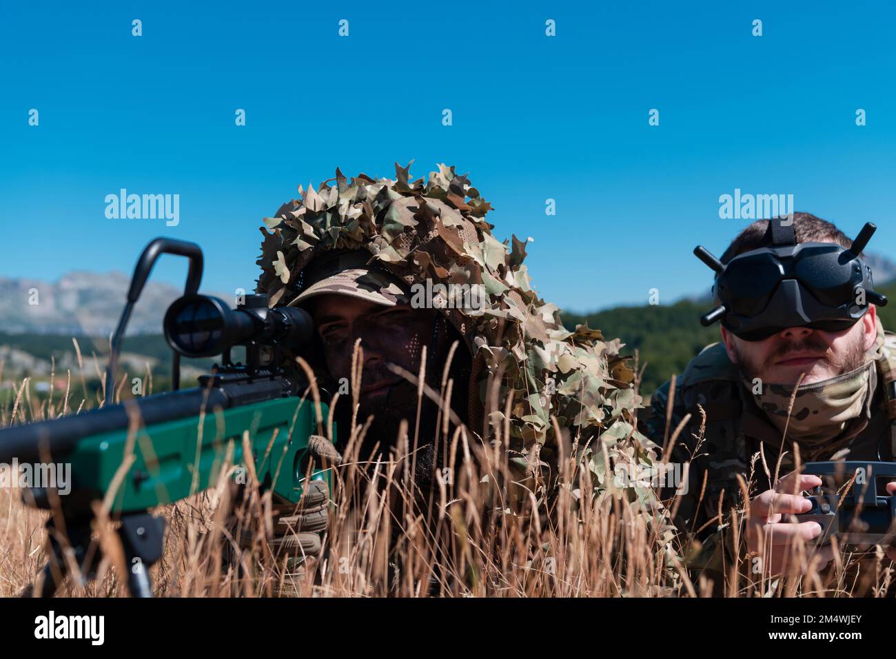 Sniper soldier assisted by an assistant to observe the area to be ...