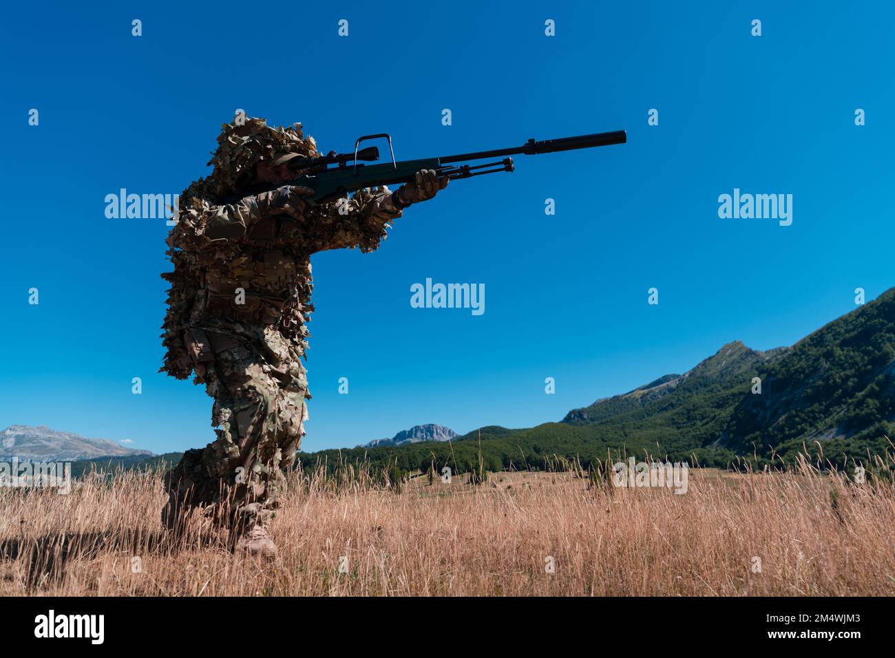 Army soldier holding a sniper rifle with scope and walking in the ...