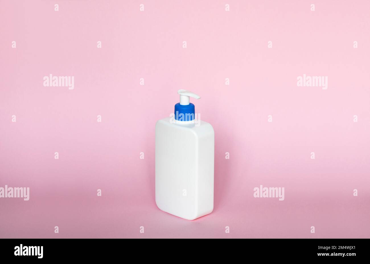 White unbranded bottle with a dispenser isolated on pink background ...