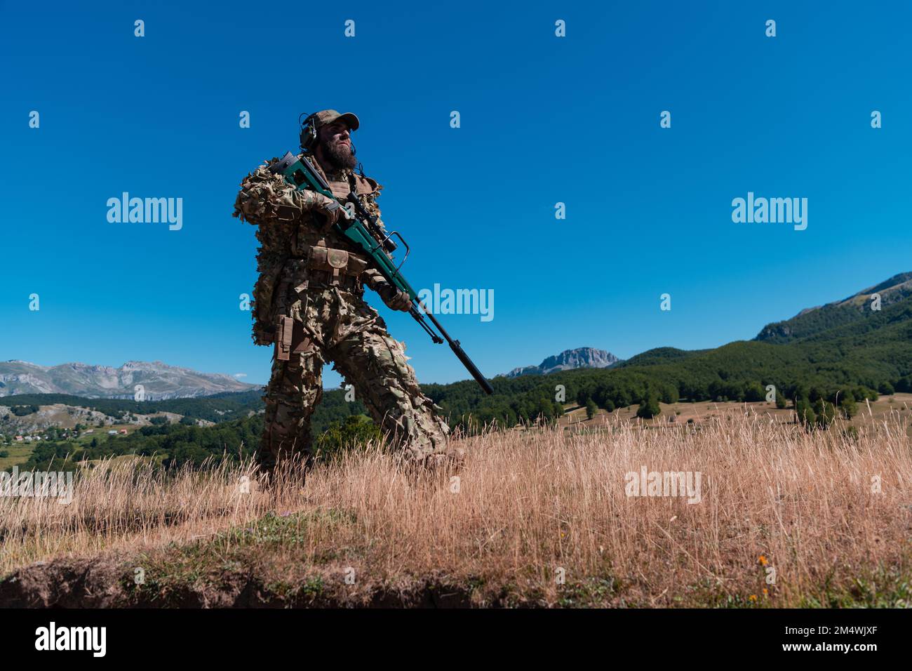Army soldier holding a sniper rifle with scope and walking in the ...