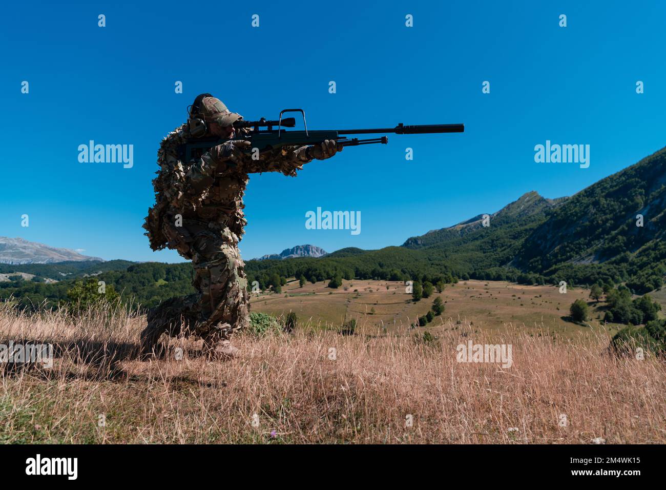Army soldier holding a sniper rifle with scope and walking in the ...