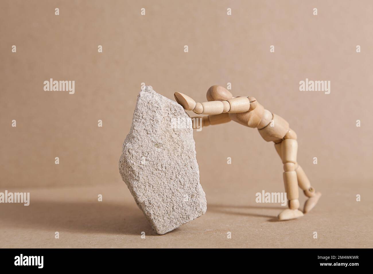 Business concept, wooden man pushing large stone Stock Photo - Alamy