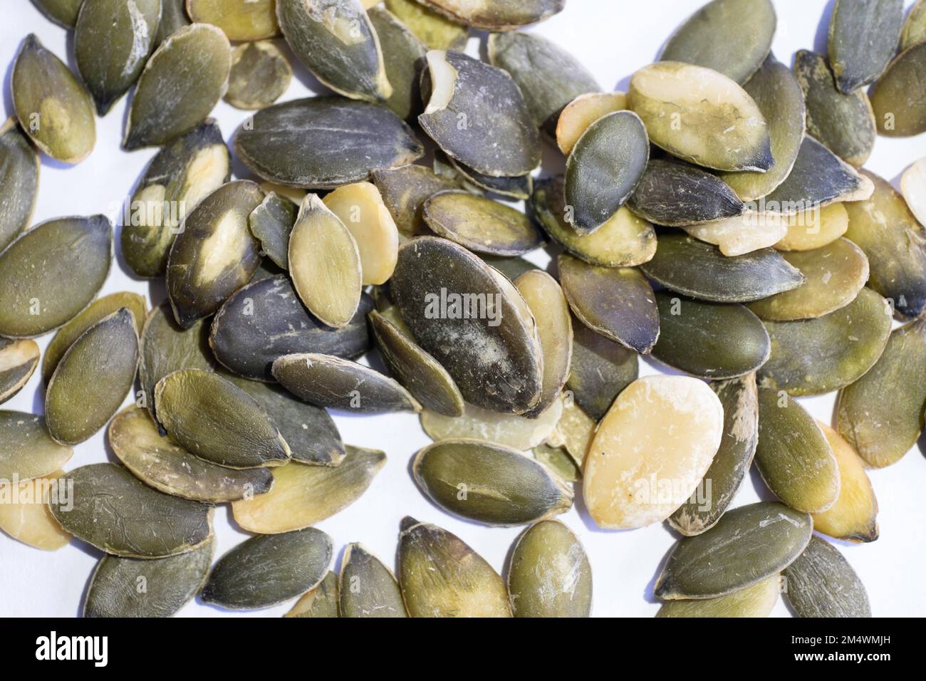 Pumpkin seeds. Some with a white outer skin and others are light green ...