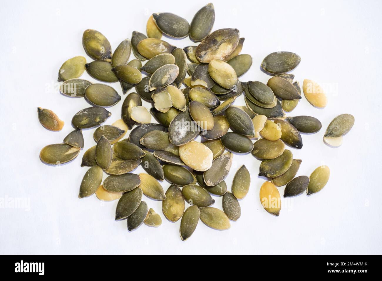Pumpkin seeds. Some with a white outer skin and others are light green ...