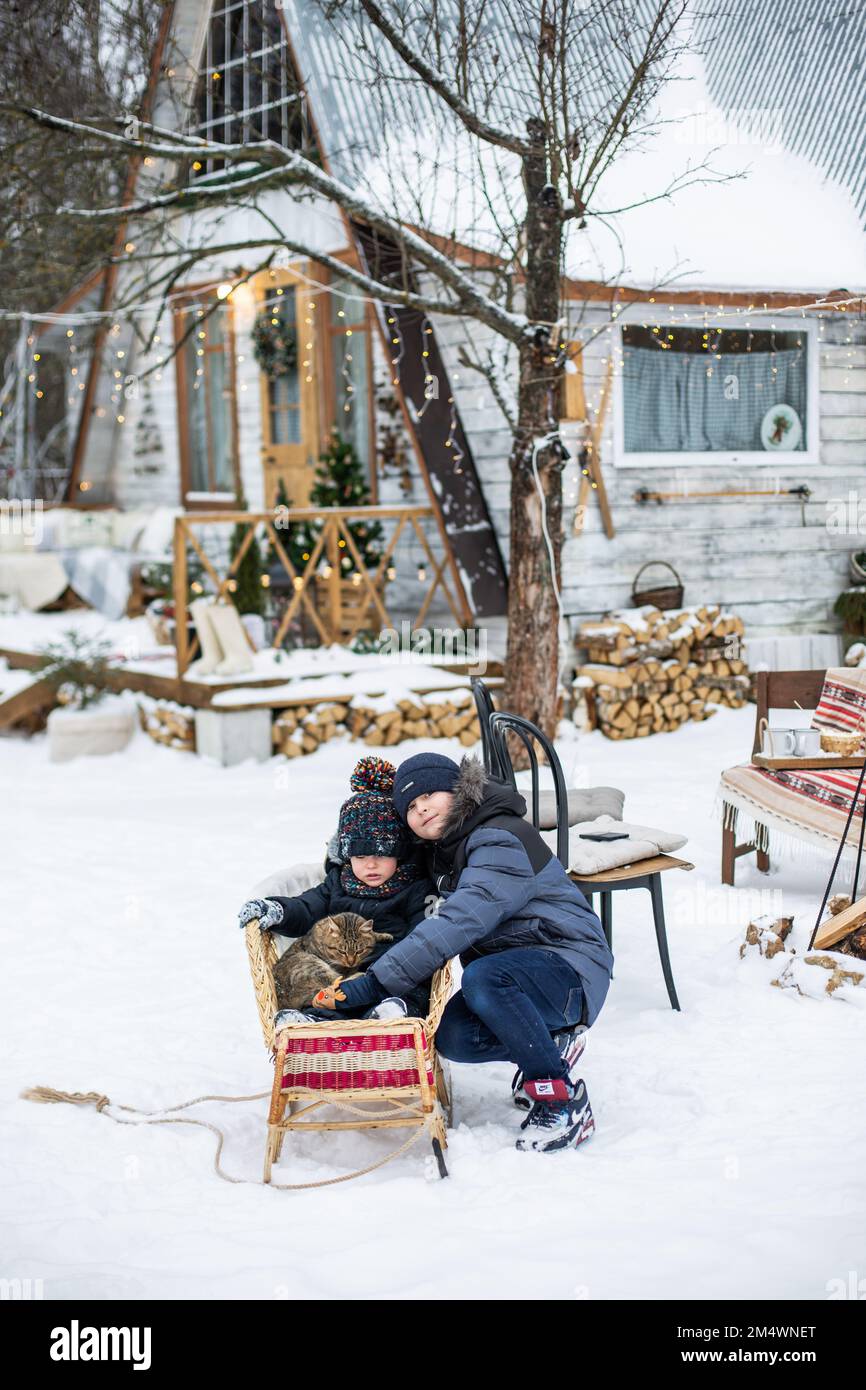 Boy pulling his friend on a sledge Stock Photo - Alamy