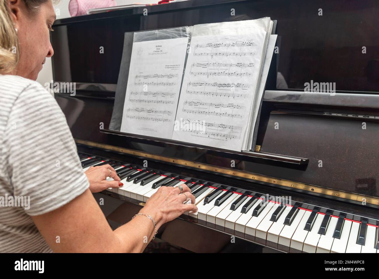 Beautiful Brazilian pianist woman touching piano keys, playing upright ...