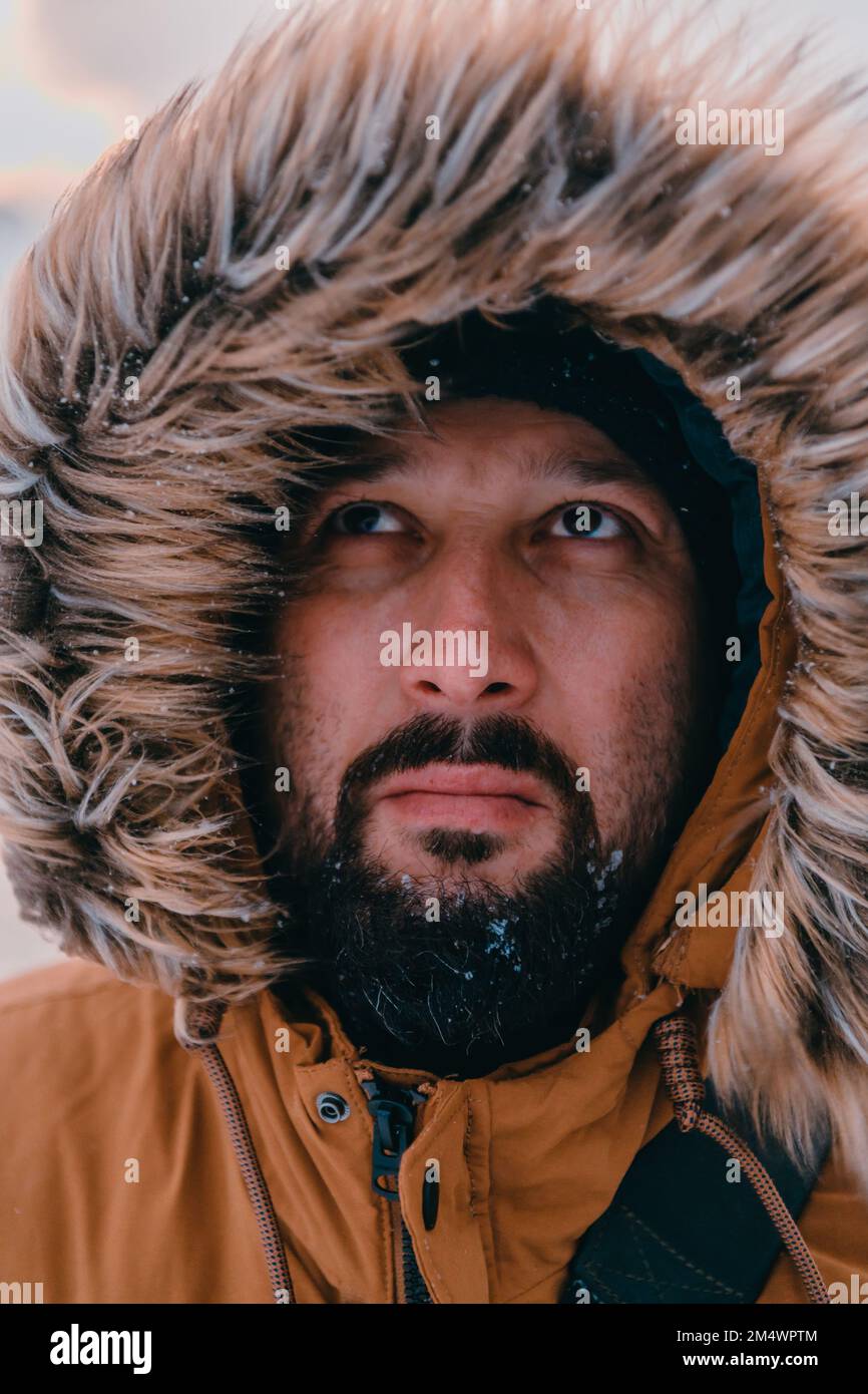 Headshot photo of a man in a cold snowy area wearing a thick brown ...