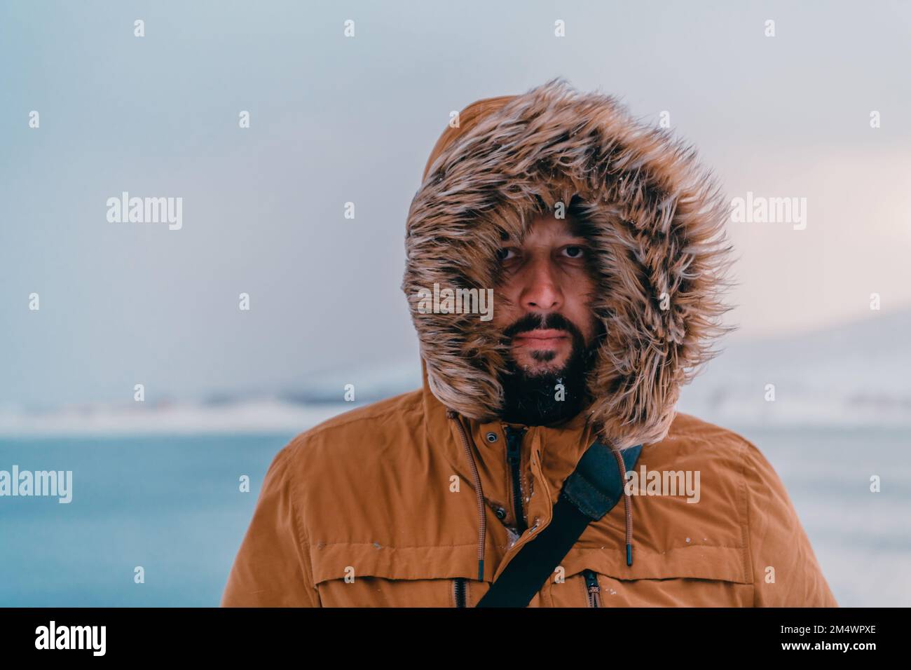 Headshot photo of a man in a cold snowy area wearing a thick brown ...