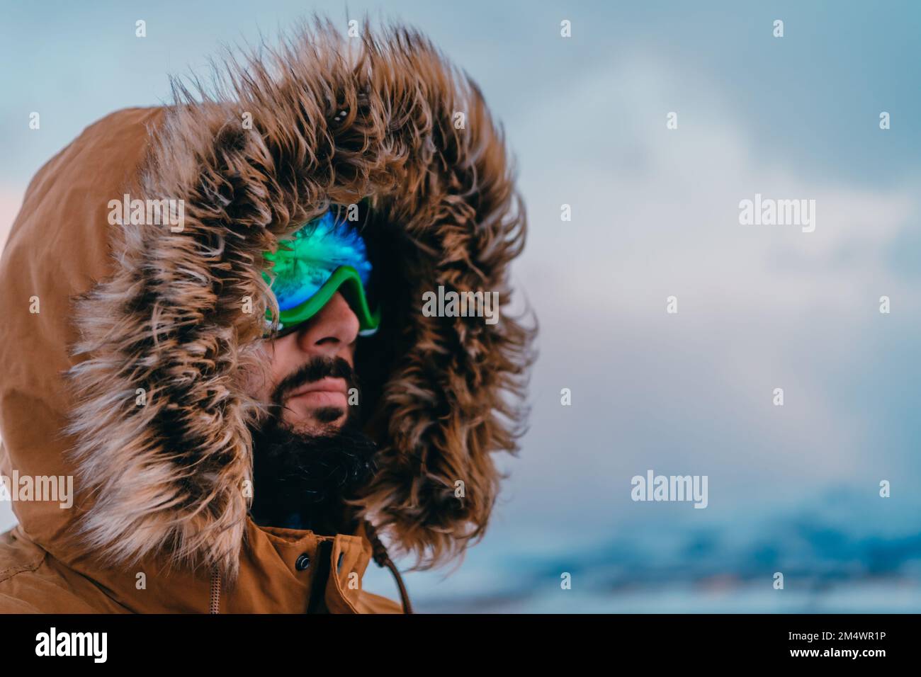 Headshot photo of a man in a cold snowy area wearing a thick brown ...