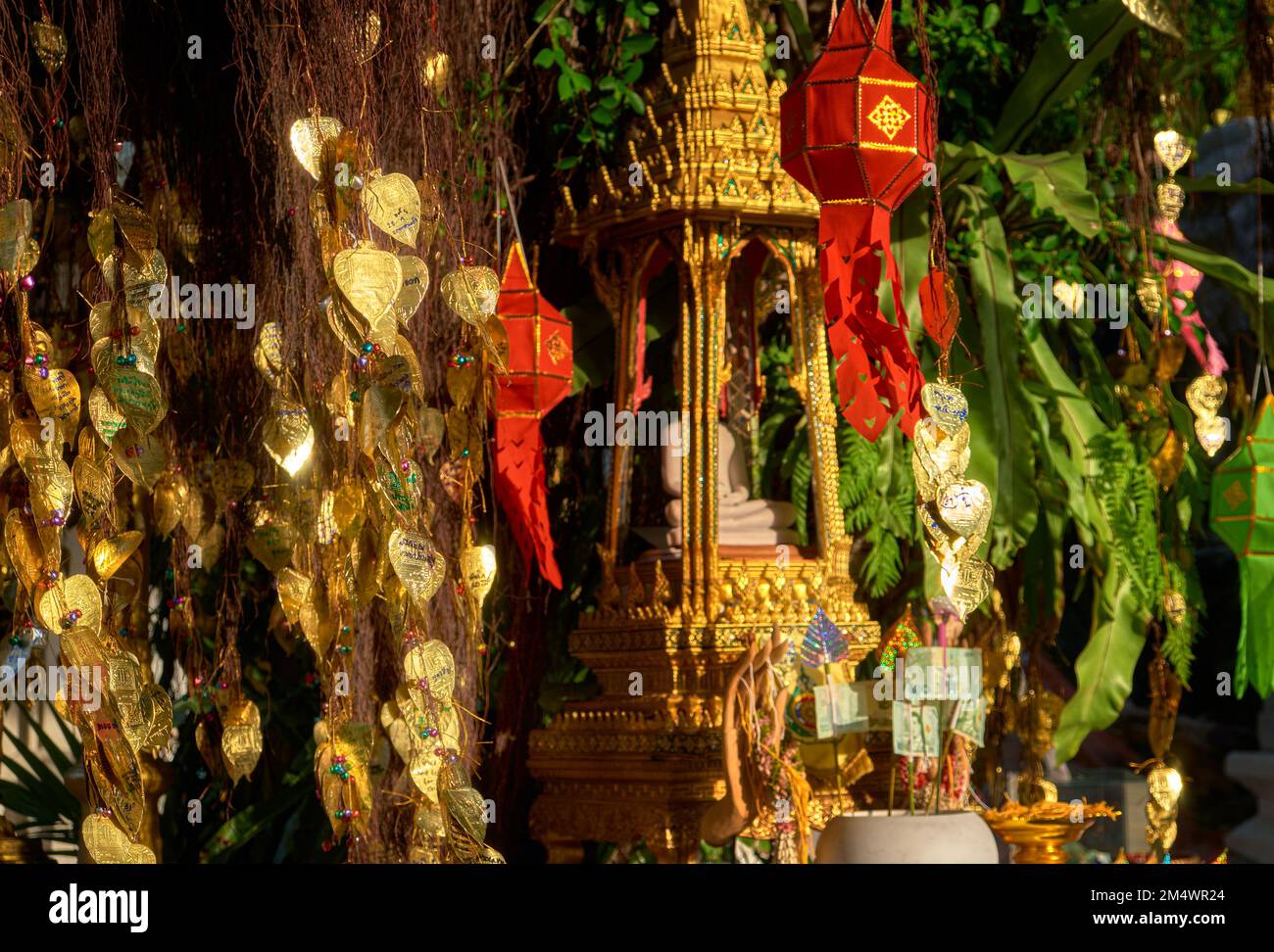Thai Buddha altar, offerings, lanterns, golden leaves of Bodhi tree ...