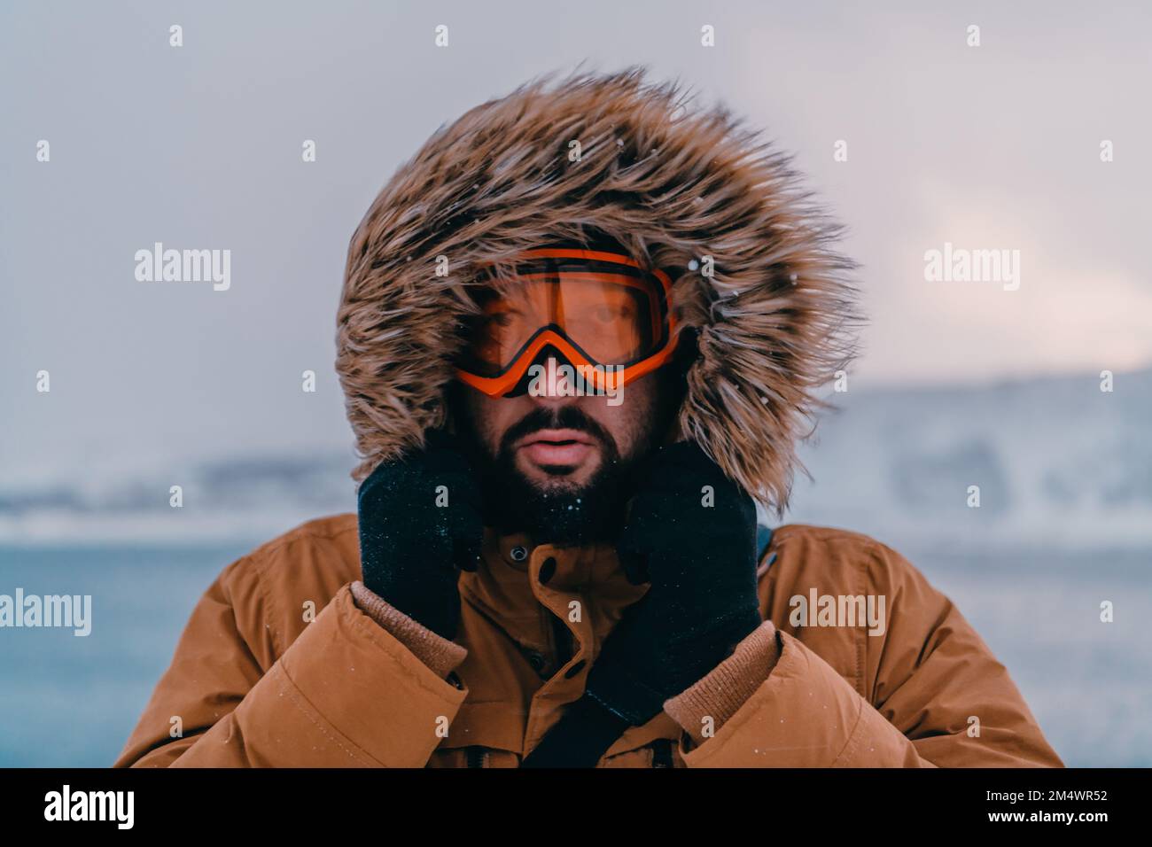 Headshot photo of a man in a cold snowy area wearing a thick brown ...