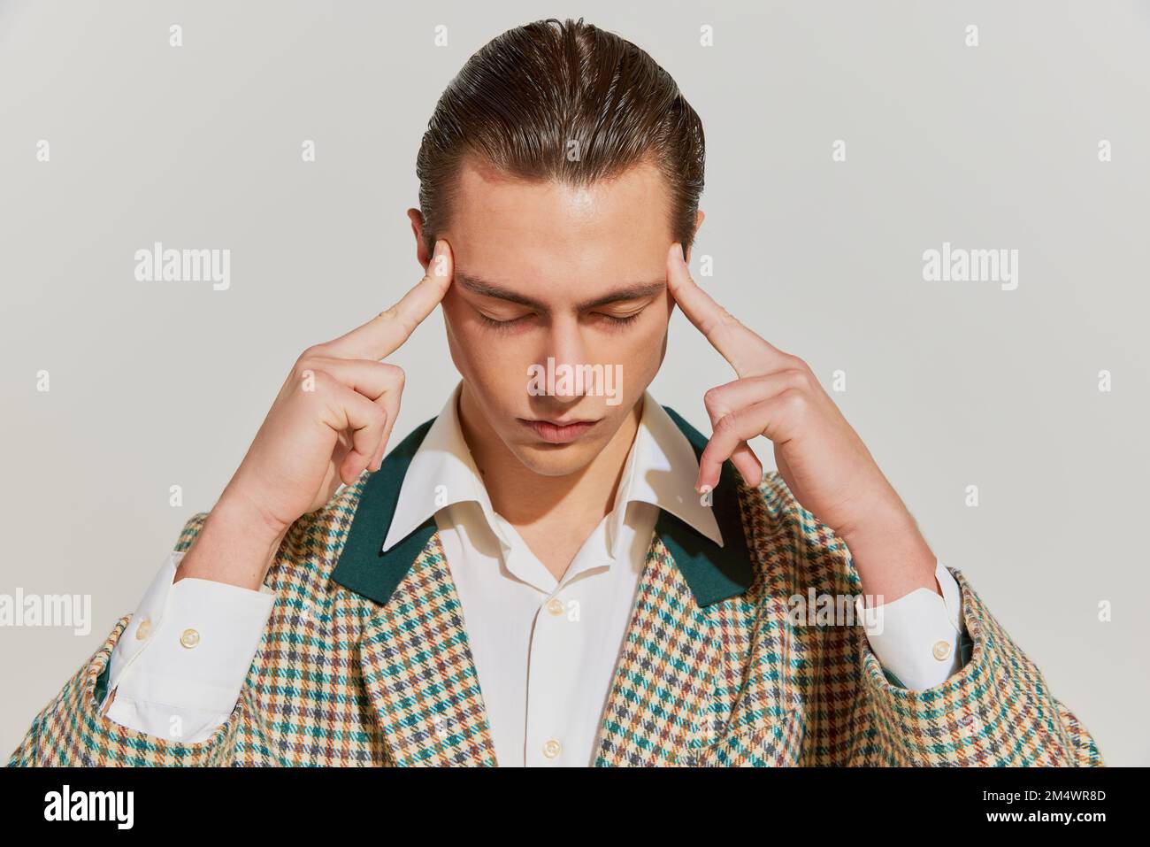 Young sad handsome man with retro style hairdo in vintage jacket ...