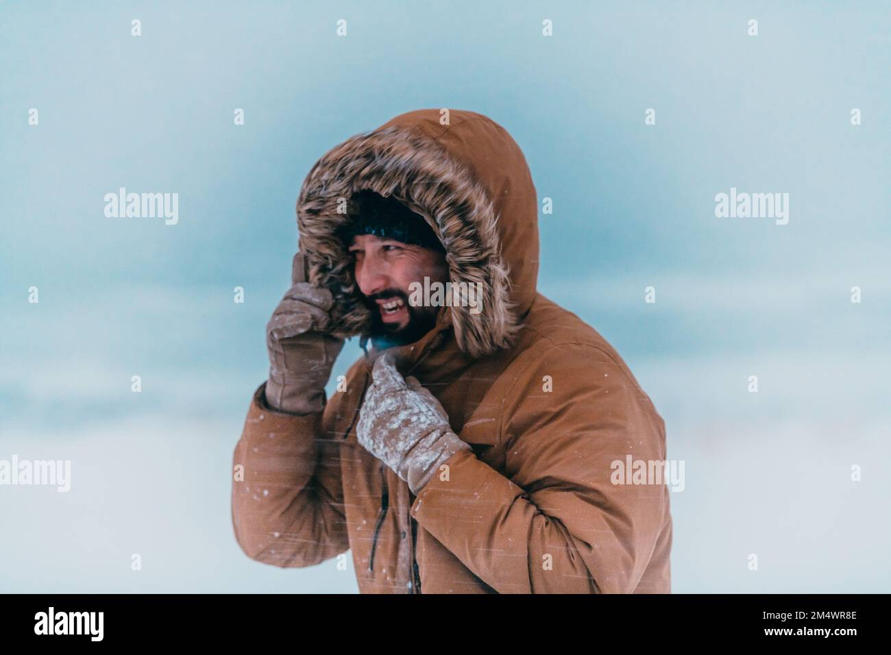 Headshot photo of a man in a cold snowy area wearing a thick brown ...
