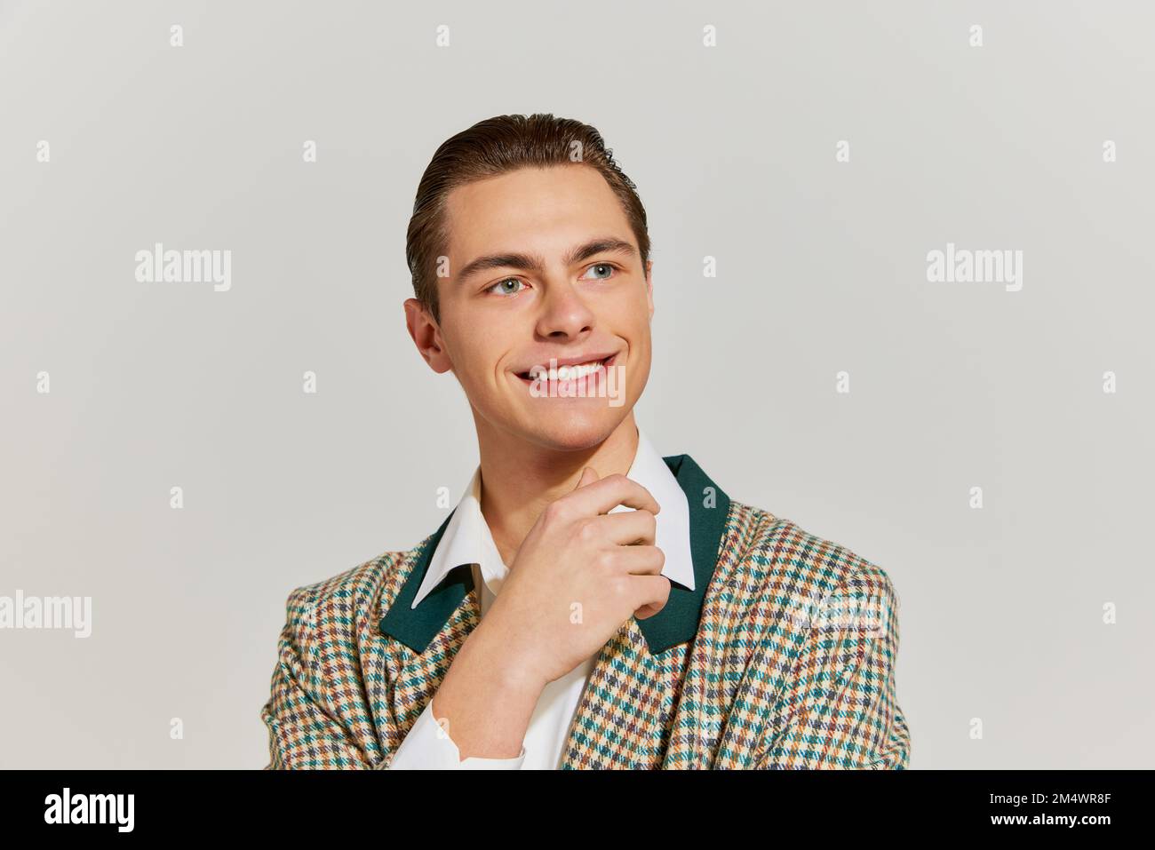 Excited young handsome man in retro style fashion outfit looking away ...