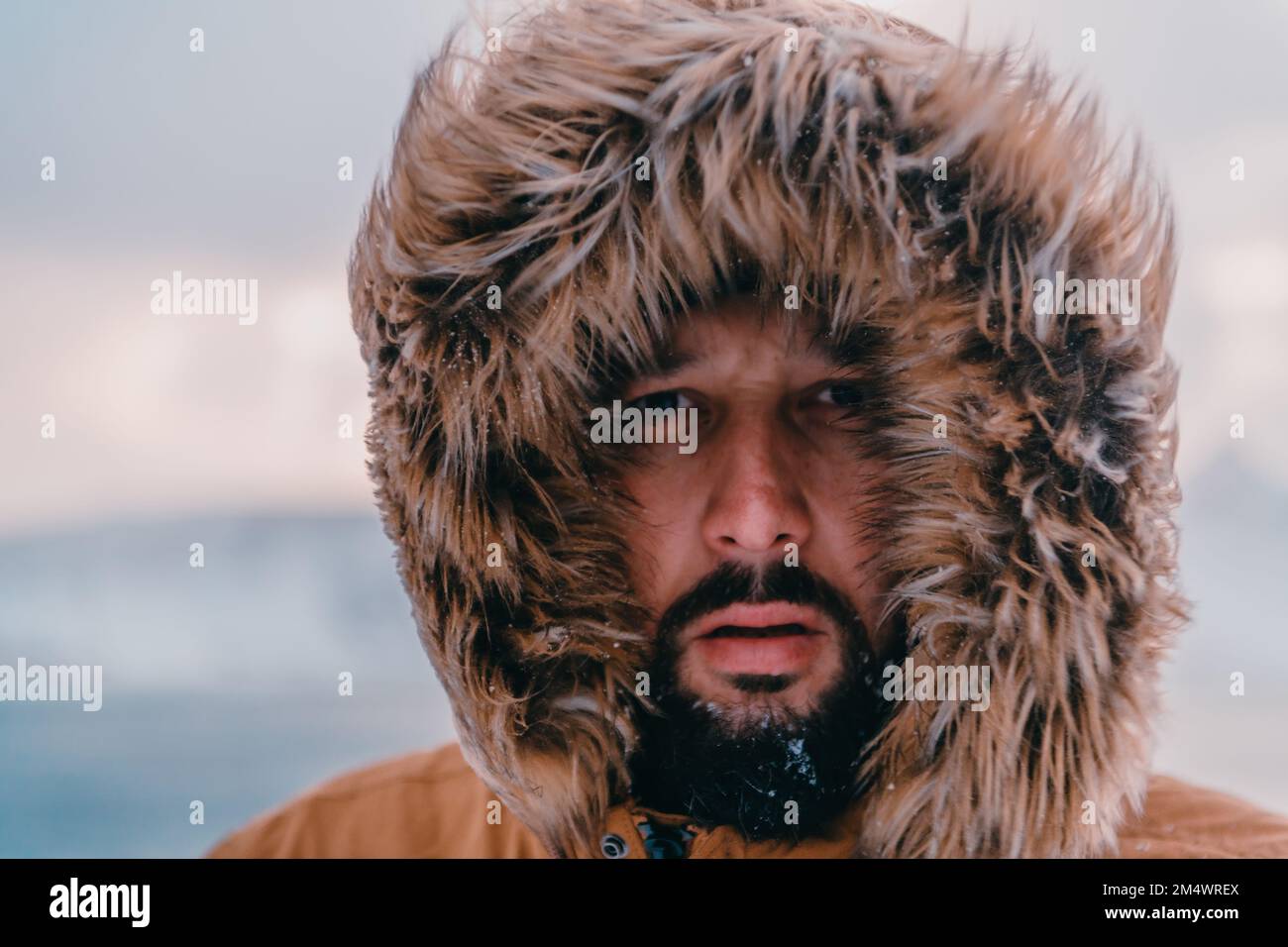 Headshot photo of a man in a cold snowy area wearing a thick brown ...