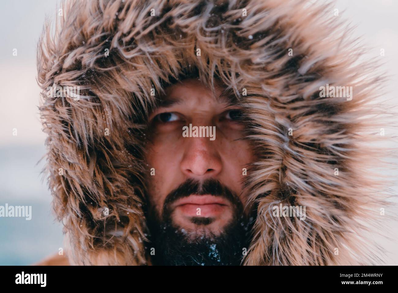 Headshot photo of a man in a cold snowy area wearing a thick brown ...