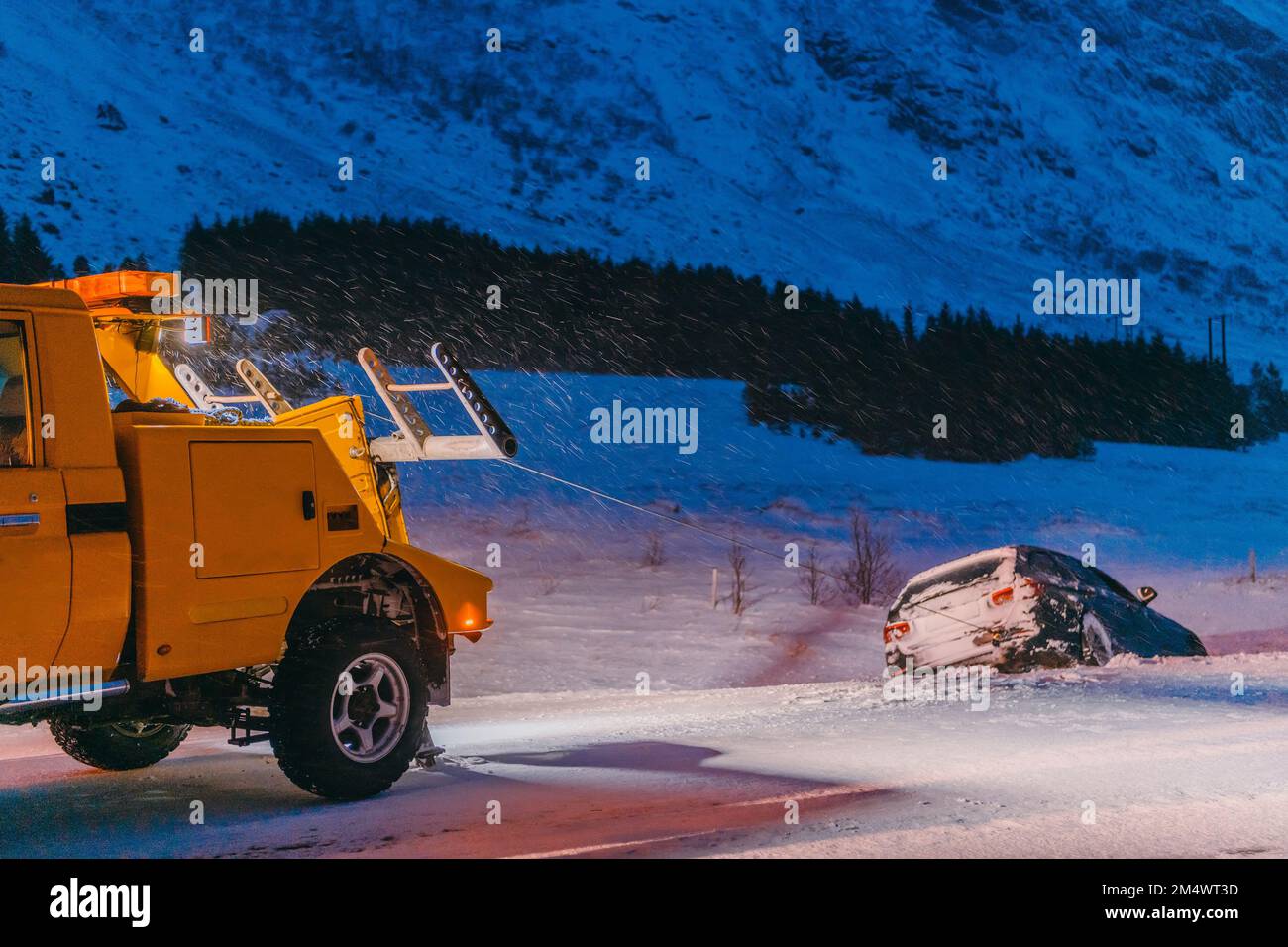 The roadside assistance service pulling the car out of the canal. An ...