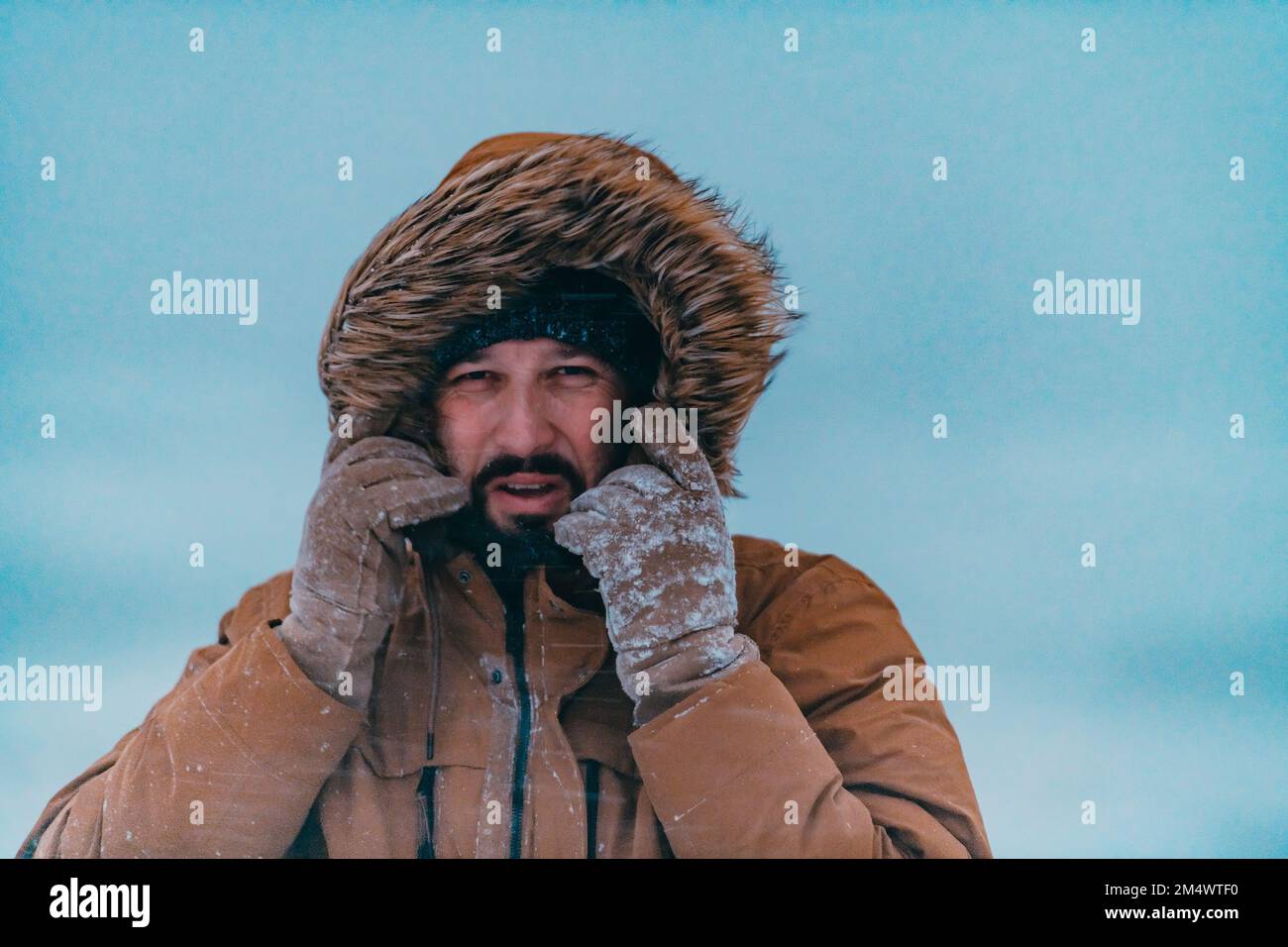 Headshot photo of a man in a cold snowy area wearing a thick brown ...