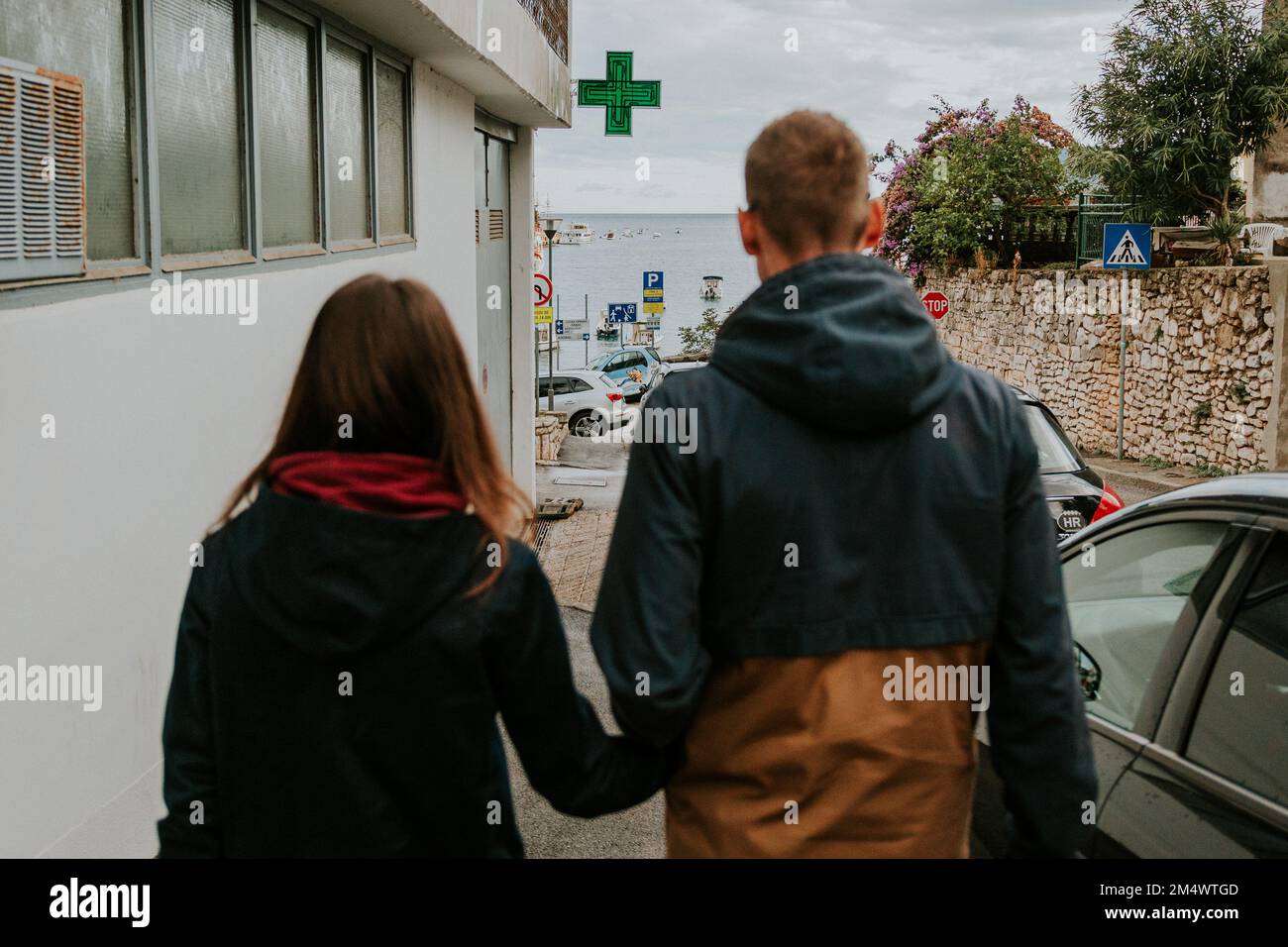Couple walking alongside the sea Stock Photo - Alamy