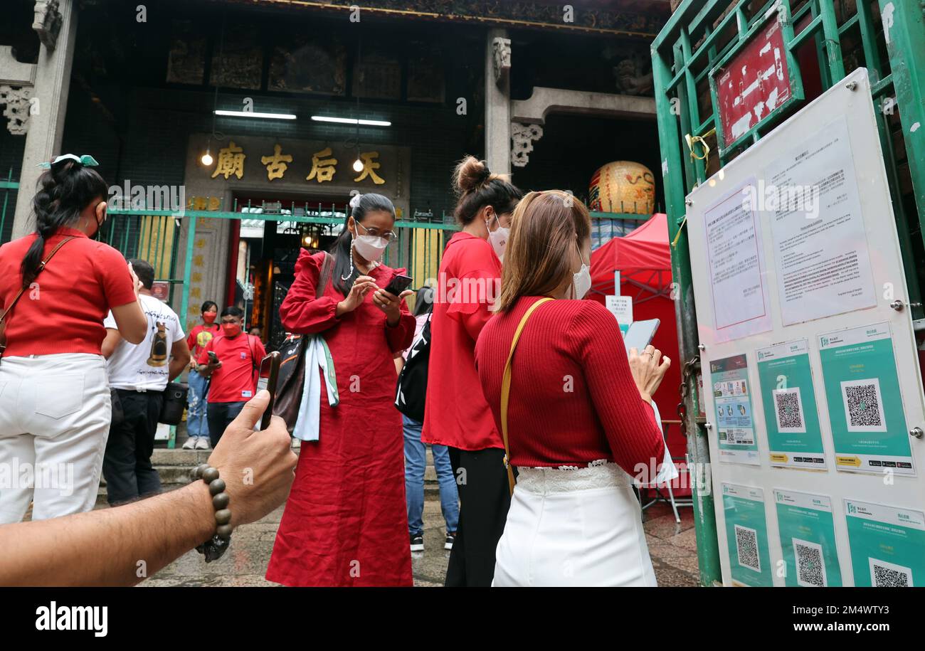 Members of a tour group from Thailand scan their LeaveHomeSafe (LHS) QR code to enter Tin Hau ...