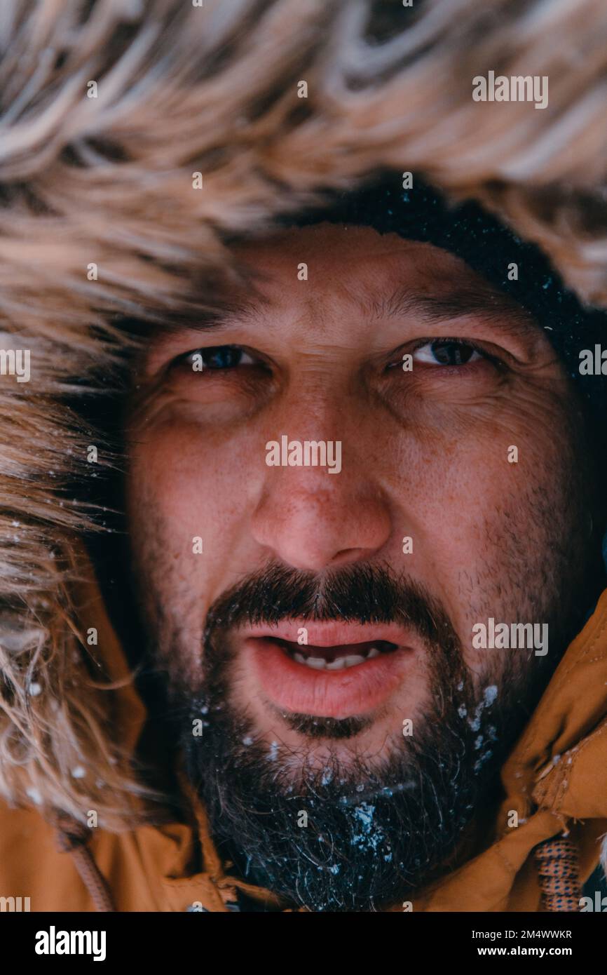 Headshot photo of a man in a cold snowy area wearing a thick brown ...