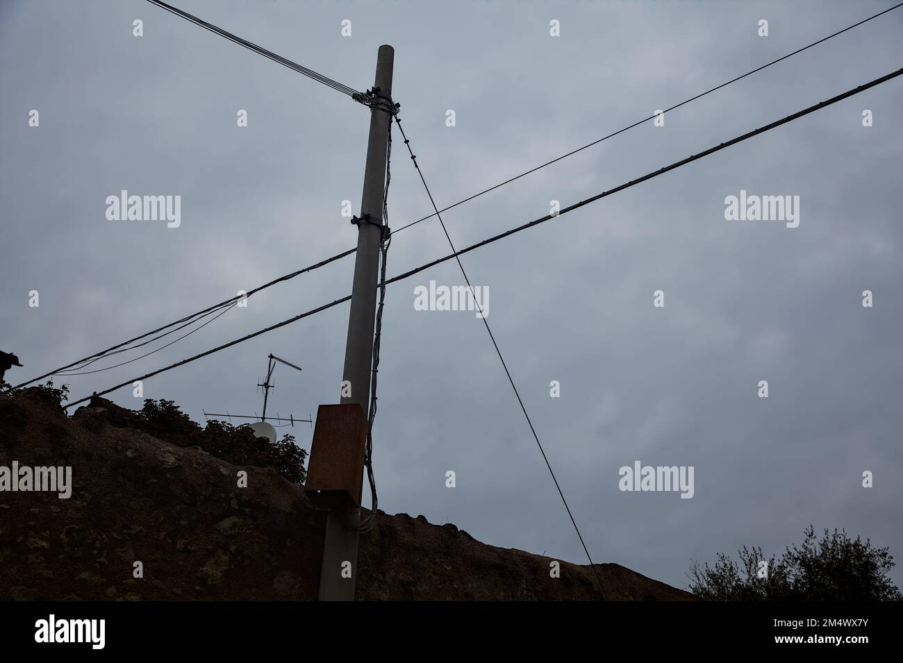 Over head cables held by pylons with a cloudy sky as background Stock ...