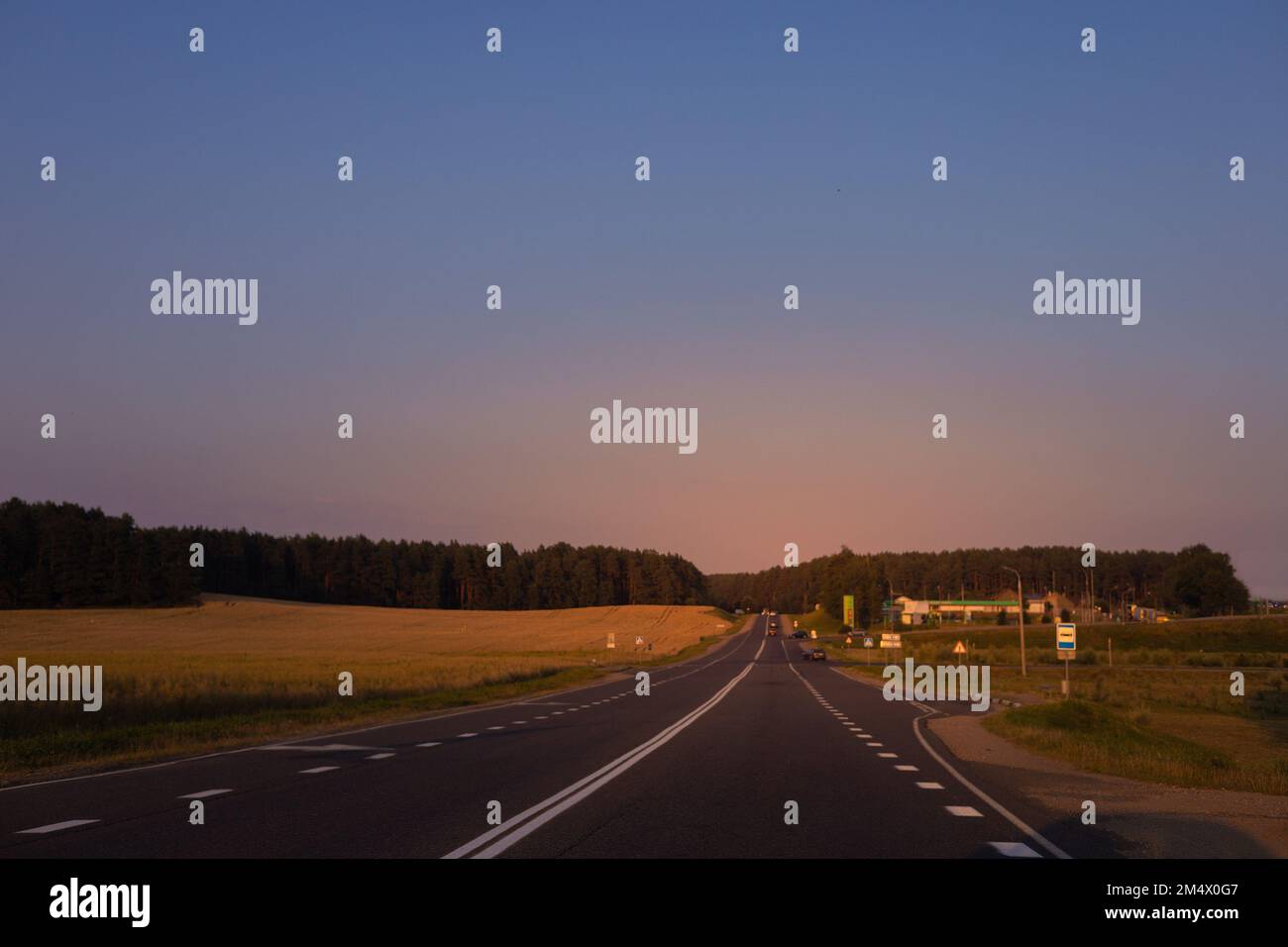 Evening view at sunset. Highway road in the countryside, roadside and ...