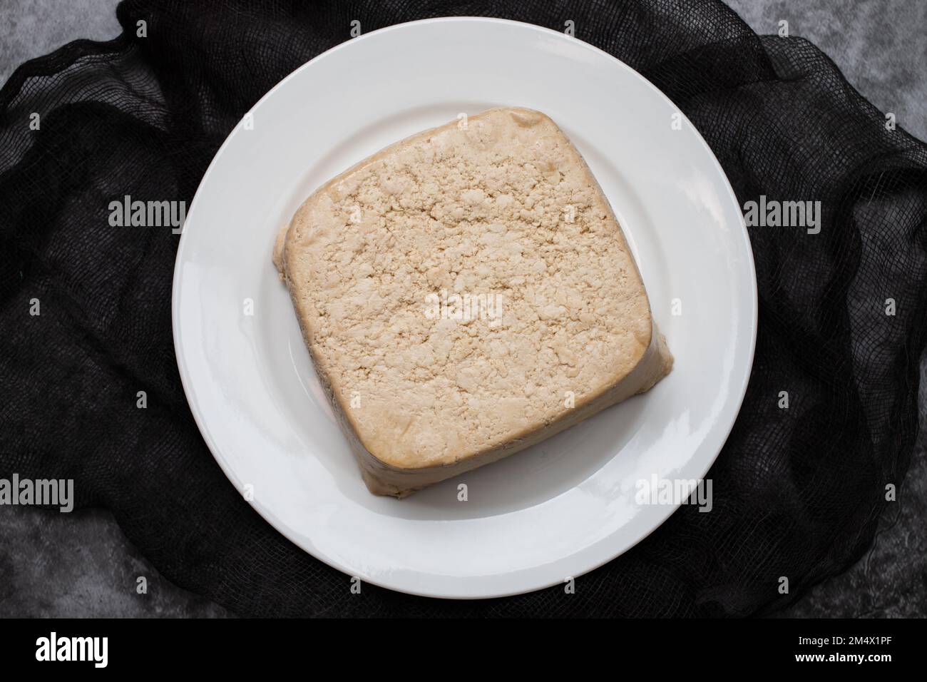 raw tofu block on white small dish on gray ceramic Stock Photo - Alamy