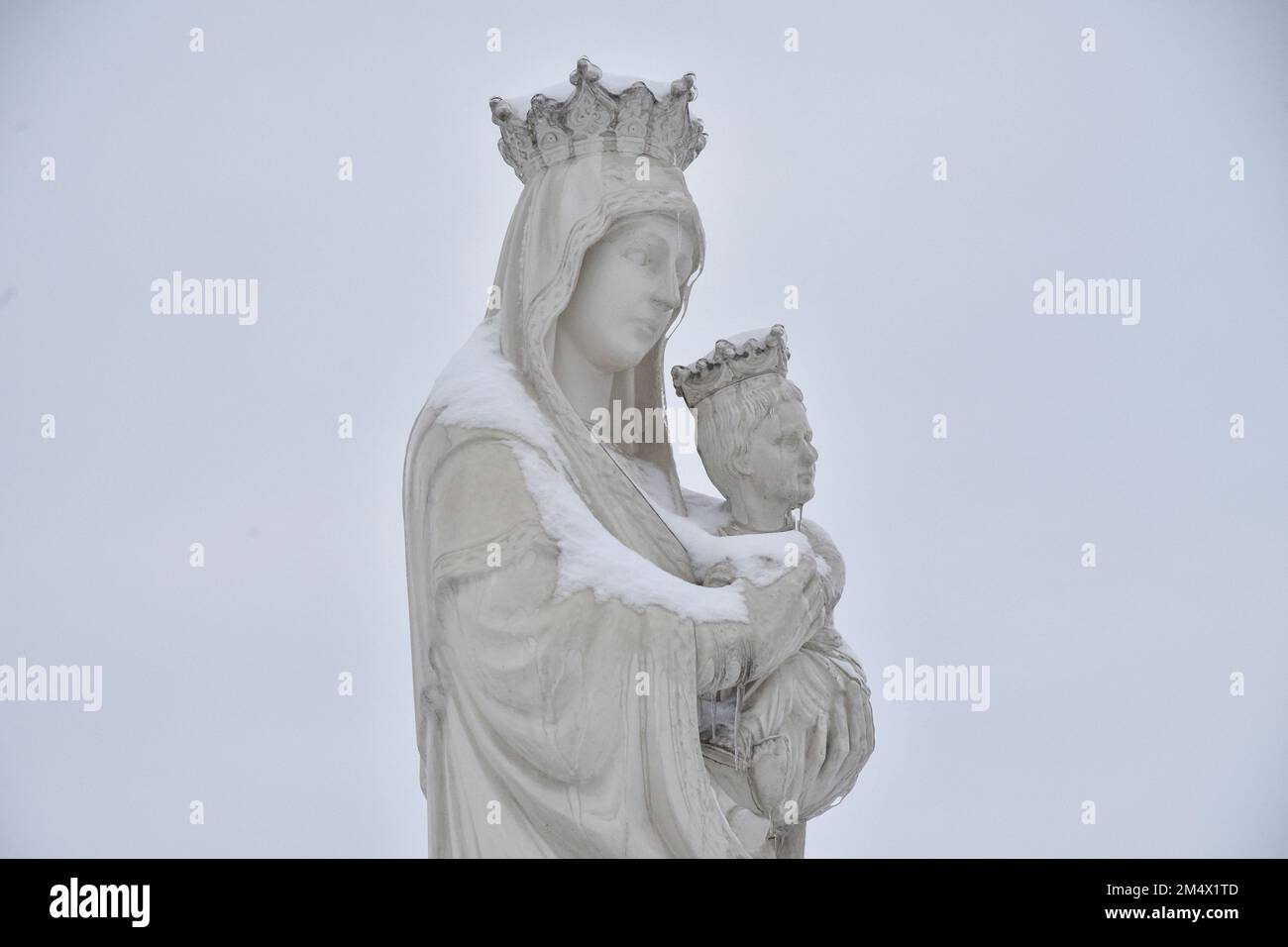 A sculpture of the Virgin Mary and Jesus covered in ice after freezing ...