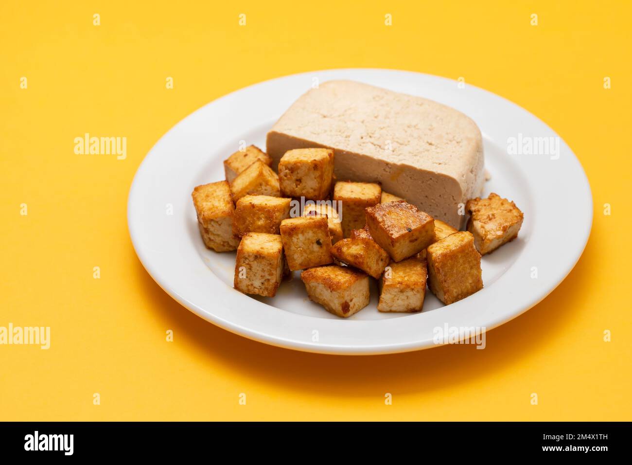 raw tofu block and fried on white small dish on yellow paper Stock ...