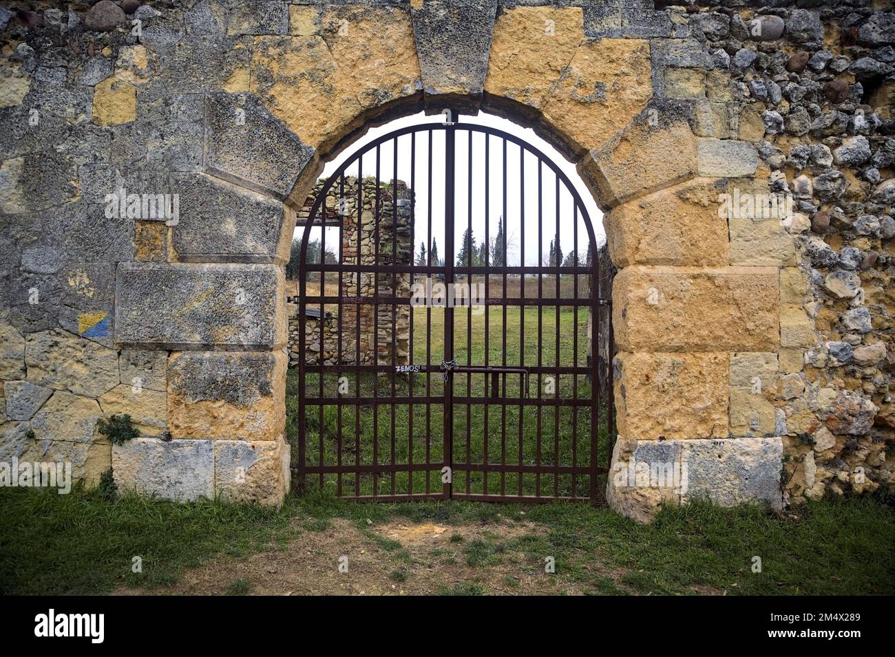 Closed gate in a fortification with a garden behind it Stock Photo - Alamy