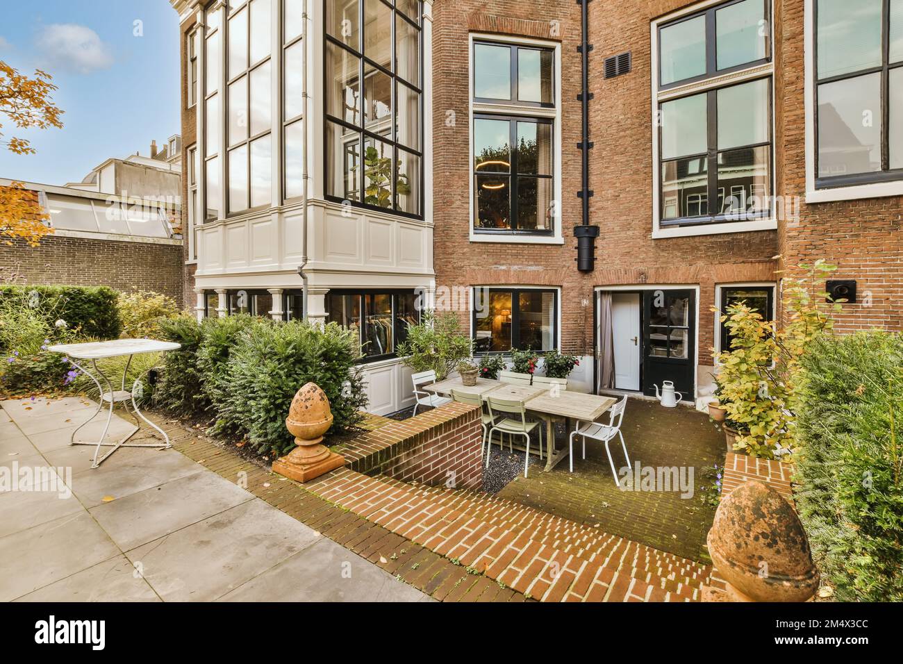 an apartment with brick patios and plants in the fore - image viatafo ...