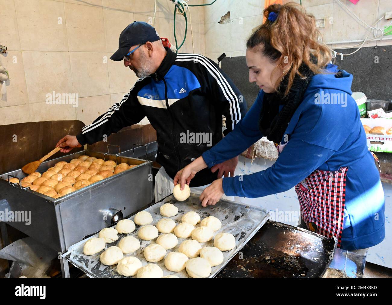 Jerusalem, Israel. 23rd Dec, 2022. A baker deep friends sufganiyot ...