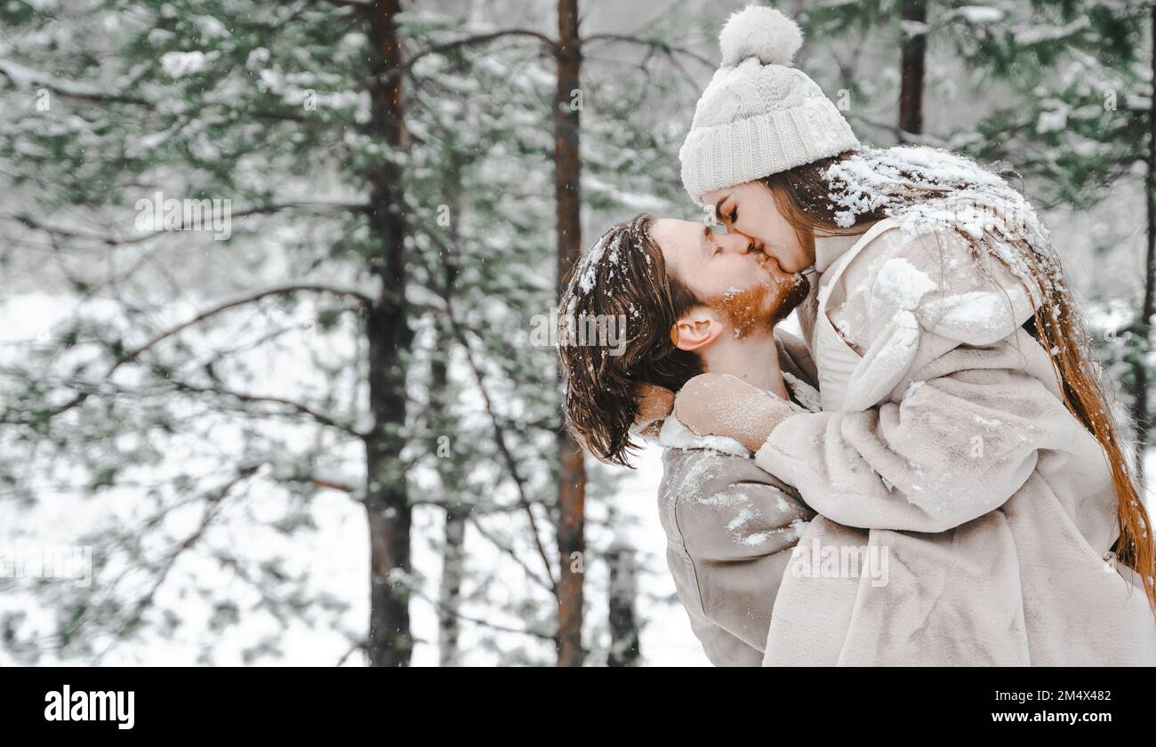 Romantic snow love story.Young couple guy girl playing kissing in snowy ...