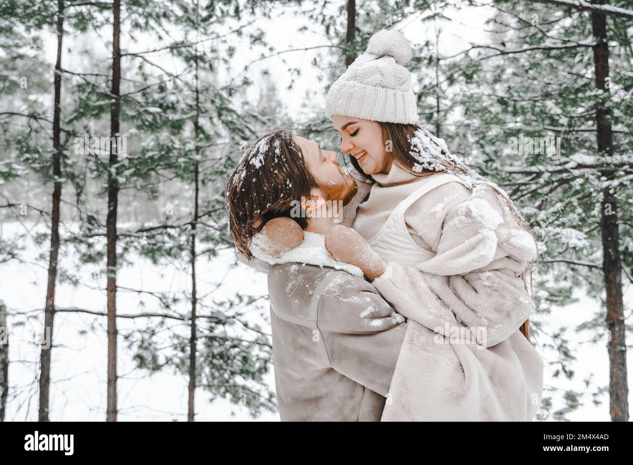 Romantic snow love story.Young couple guy girl playing kissing in snowy ...