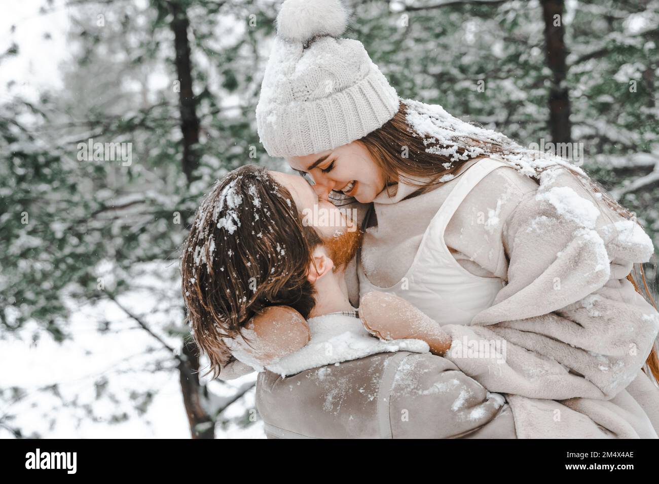 Romantic snow love story.Young couple guy girl playing kissing in snowy ...
