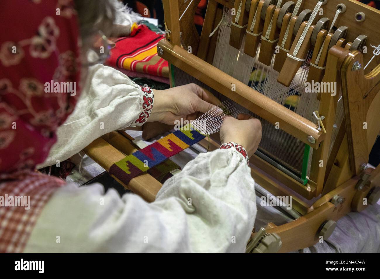 Moscow, Russia. 18th December, 2022. A woman weaves fabric on an old ...